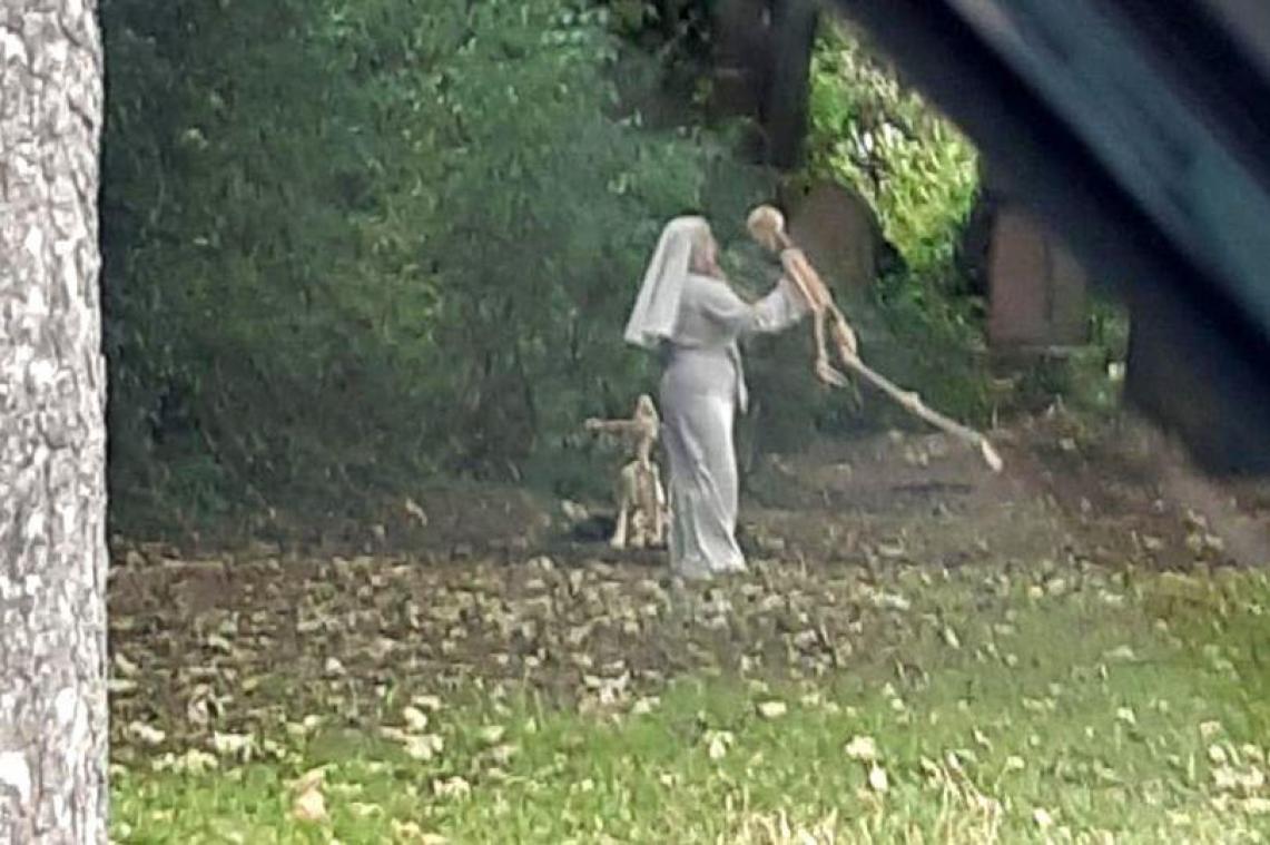 Macaber zicht: vrouw verkleed als non danst met skeletten op oud ...
